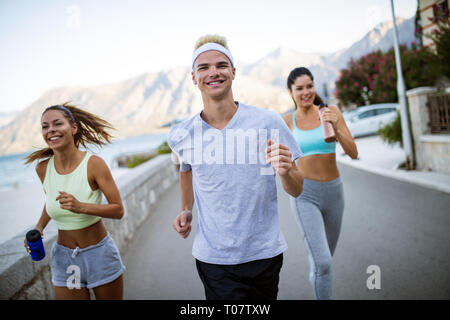 Outdoor portrait of group of friends running and jogging in nature ...
