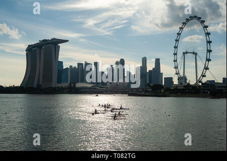 The silhouette of the Marina Bay Sands hotel against the bright golden ...