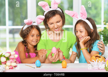 Portrait of mother and daughters coloring Easter eggs Stock Photo - Alamy