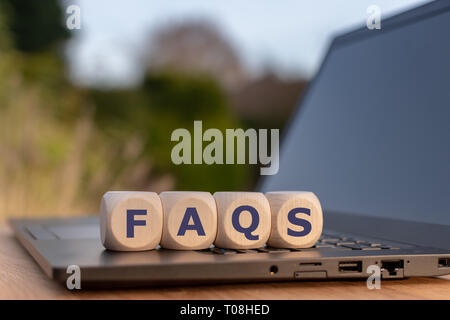 Cubes on a notebook form the abbreviation "FAQS Stock Photo - Alamy