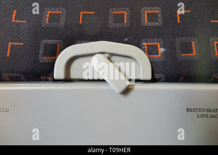 The latch / catch of a passenger 's seat tray table in folded up ...