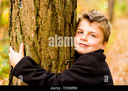 kid in a forest hugging a tree Stock Photo - Alamy