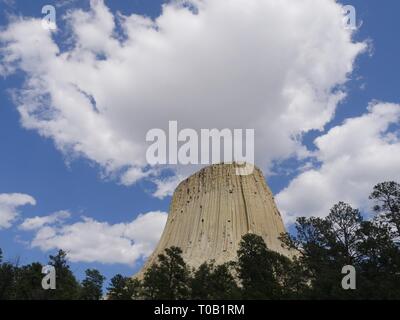 Medium wide shot of the Devils Tower, with a United States flag flying ...