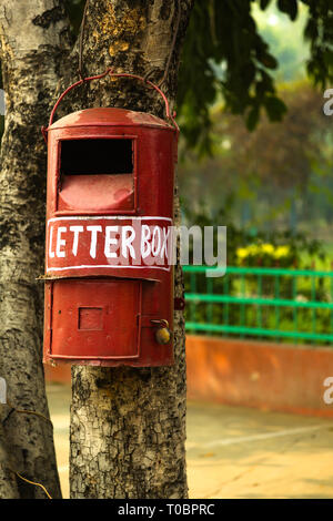 Red letter box with background of India Post, Pune University campus at ...