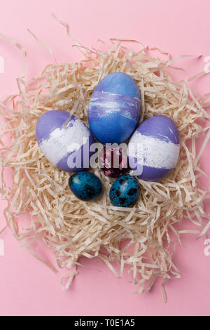 Quail eggs in a violet colorful wool nest with knitting needles ...