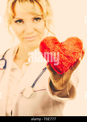 Doctor cardiologist in white apron with stethoscope showing ...