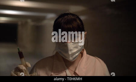 nurse goes to make an injection looks at the camera horror fear of ...