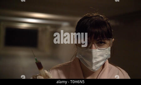 nurse goes to make an injection looks at the camera horror fear of ...