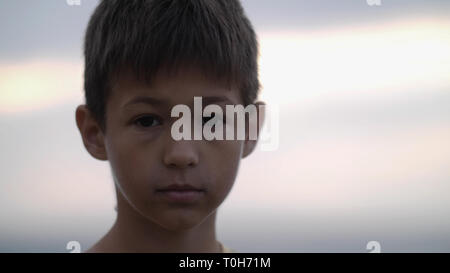 portrait emaciated refugee boy stands alone near a broken window ...