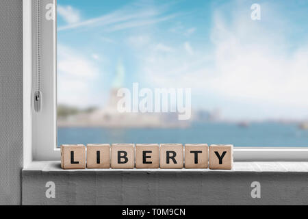 Liberty sign in a window sill with a view to the statue of liberty ...