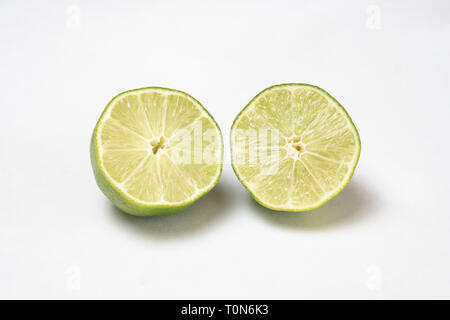 a cutted lime on a plain white table Stock Photo - Alamy