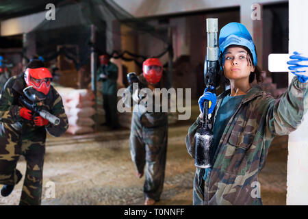 Girl in blue mask is making selfie by smartphone on battlefield of ...