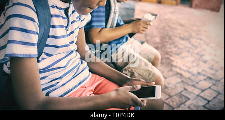 Schoolboys using mobile phones at corridor in school Stock Photo - Alamy