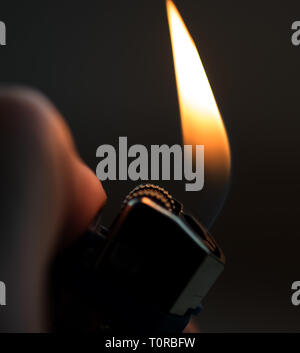 Closeup to hand igniting fire lighters with black background. Energy ...