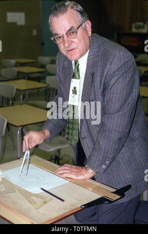 Aged male math teacher in the classroom Stock Photo - Alamy