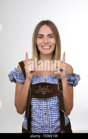 Pretty Oktoberfest woman with blue white dirndl holds a pretzel Stock ...