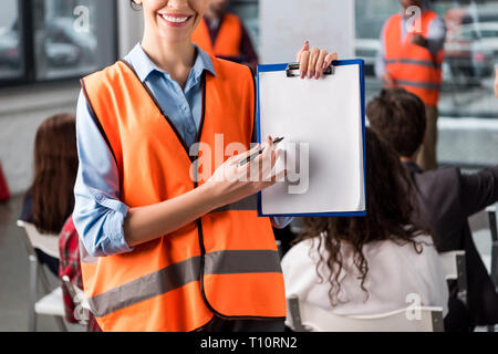 selective focus of cheerful female firefighter pointing at blank ...