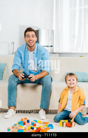 Smiling boy playing with colorful plastic blocks with grandfather Stock ...