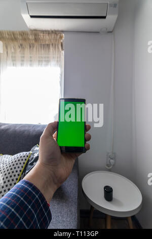Air conditioner smartphone remote control concept. Hand holding a phone ...