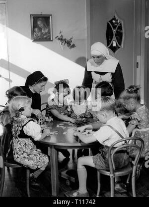 Teacher and toddler playing with toys sitting on table at kindergarten ...