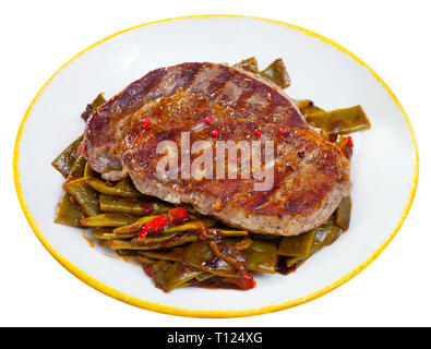 Appetizing string beans stewed with bell pepper on white plate served ...