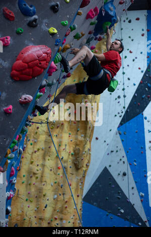 A rock climbing instructor climbs an indoor climbing wall Stock Photo ...