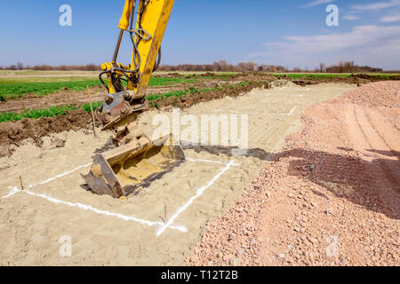 Excavator will excavate square trench that is marked with white powder ...