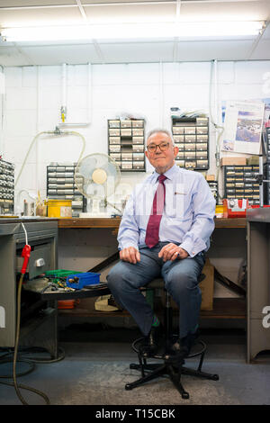 A friendly older gentleman / business owner standing in and on the ...