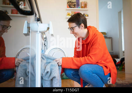 Young woman doing laundry at home Stock Photo - Alamy