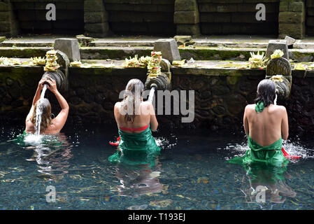 Balinese woman bathing in the holy waters of Tirta Empul temple in Bali ...