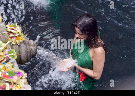 Woman in holy spring water temple in bali. The temple compound consists ...