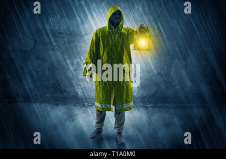 Ugly wayfarer with lantern in his hand in front of a crumbly wall ...