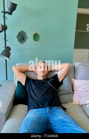 Handsome guy posing - lying down, feel the music with raised hand Stock ...