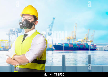 Handsome asian worker with protective mask and yellow helmet standing ...