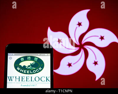 In this photo illustration a Wheelock & Co logo seen displayed on a ...