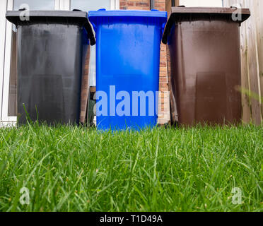 Colour-coded household waste collection bins for green (organic) waste ...