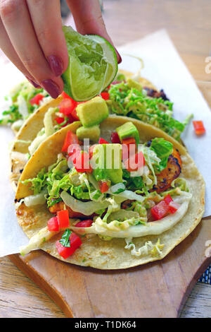Eating three fish tacos with fresh salsa and avocado Stock Photo - Alamy