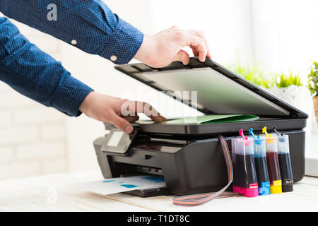 Man's hand making copies. Working with printer Stock Photo - Alamy