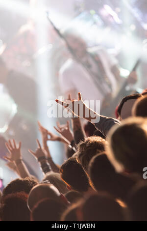 Rock concert, people with raised up hands dancing and enjoying loud ...