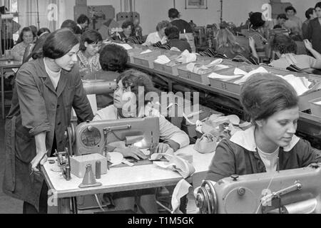 female workers operate sewing machines in a busy factory 1960s hungary ...