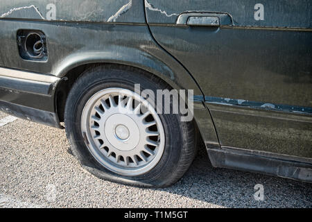 Wasted care with punctured tyres and and open fuel tank Stock Photo - Alamy
