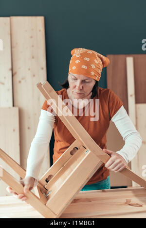 female carpenter repairing wooden chair Stock Photo - Alamy