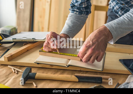 Carpenter making wooden picture frame in small business woodwork ...