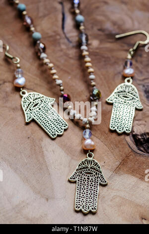 Hamsa Fatima hand metal pendant jewelry set on wooden background Stock ...