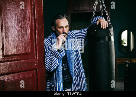 Handsome drunk man smokes and leans on a punching boxing bag Stock ...