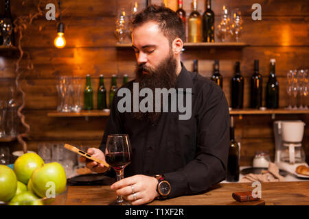 Bartender behind the counter enjoying a glass of wine and talking on ...