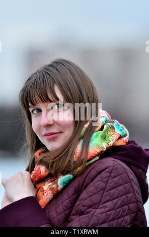 Lady in light blue coat walks down the entrance path towards the ...
