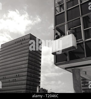 1960s, historical, two male window cleaners standing in a concrete pod ...