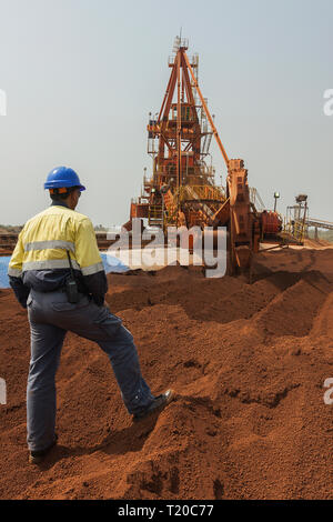 Port operations for managing and transporting iron ore.Tugs manoeuvring ...