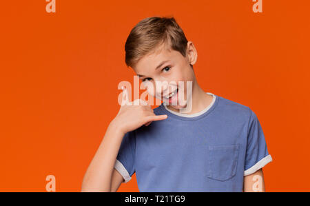 Flirty boy making call me gesture, orange background Stock Photo - Alamy